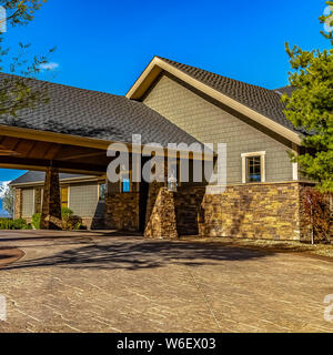 Square Home facade with view of yard and gable roofs over garage and ...