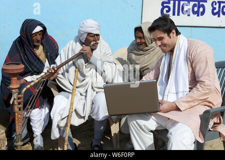 Man explaining to villagers with a laptop Stock Photo - Alamy