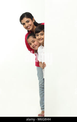 Family hiding behind a wall Stock Photo - Alamy