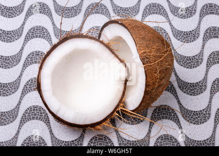 Two halves of a coconut with the brown outer shell and white coco ...