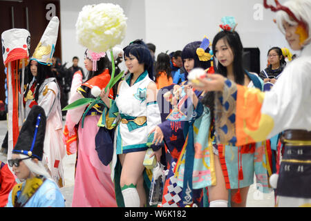 Chinese cosers dressed in cosplay costumes pose during an animation ...