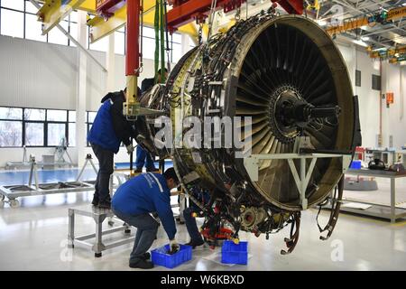 Chinese workers repair an aircraft engine at the Sichuan Services Aero ...