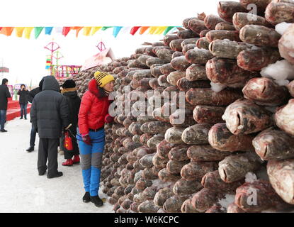 Tourists look at a 10-meter-long "fish wall" composed of more than ...