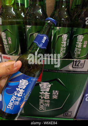 --FILE--A customer buys a bottle of Snow beer of China Resources Snow ...