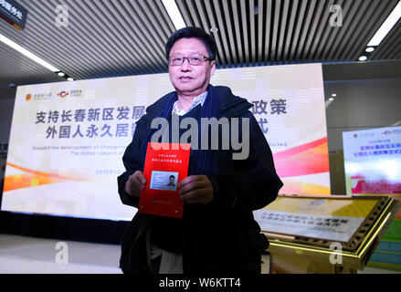 A high-quality foreign worker shows his foreign permanent resident ID ...