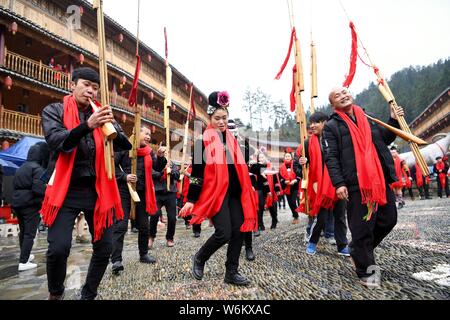Chinese men of Dong ethnic group play the traditonal wind instrument ...