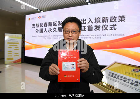 A high-quality foreign worker shows his foreign permanent resident ID ...
