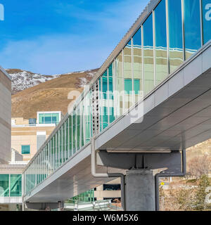 Skybridge connected to a modern building with mountain and blue sky ...