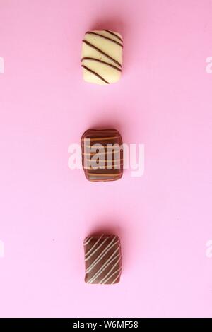 row of chocolate bonbons on a white porcelain plate Stock Photo - Alamy