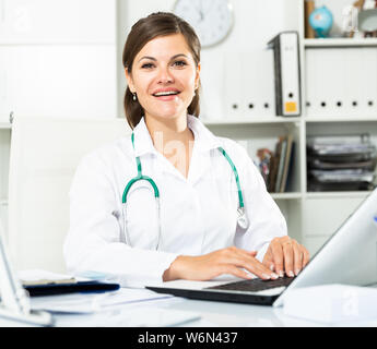 Smiling woman doctor working effectively in her office Stock Photo - Alamy