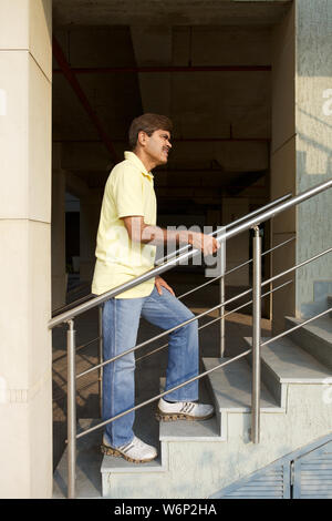 Man struggling to walk up stairs Stock Photo - Alamy