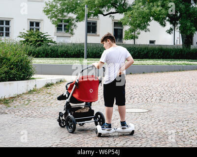 Man pushing a baby stroller on a road Stock Photo - Alamy