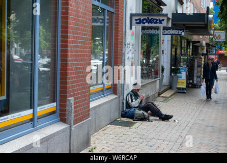 Beggar sitting at side of road with a mobile phone Stock Photo - Alamy