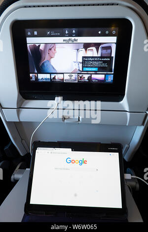 Airplane back of seat entertainment system showing movie choices ...