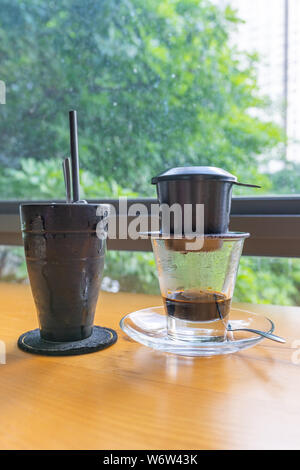 Vertical photo of traditional Vietnamese fin coffee with condensed milk ...