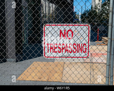 A NO TRESPASSING sign behind a chain-link fence Stock Photo - Alamy