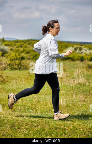 Spanish woman running on meadow Stock Photo - Alamy