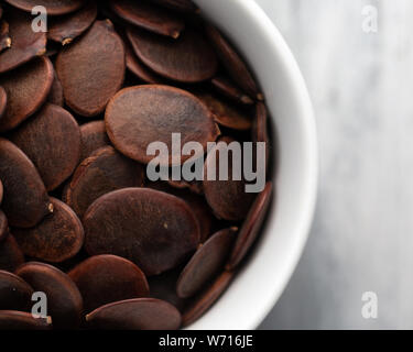 Whole achi seeds in a white bowl, off centre to the left Stock Photo ...