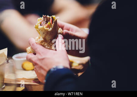 A man is eating a doner kebab Stock Photo - Alamy