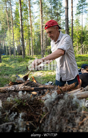 Friends wild camping in a forest Stock Photo - Alamy