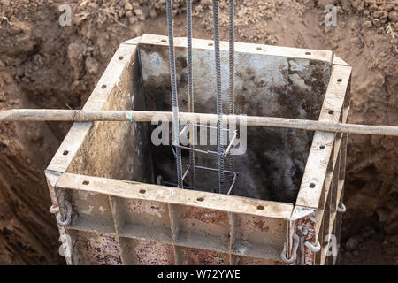 Work industrial concept : Pouring concrete into steel box for foundation pillar in process of ...