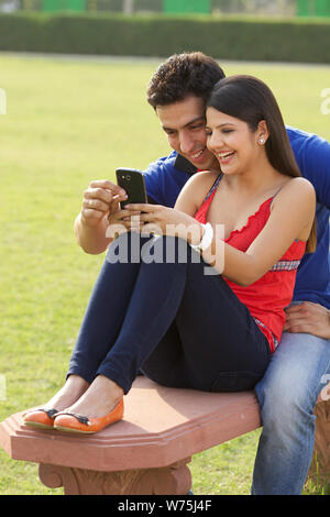 Pleased young man reading text message on smartphone Stock Photo - Alamy