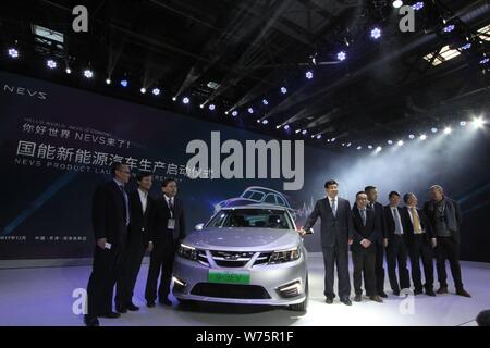 Executives and guests of National Electric Vehicle Sweden NEVS pose with the first NEVS 9 3 series EV during the off line ceremony at Tianjin Binhai Stock Photo Alamy