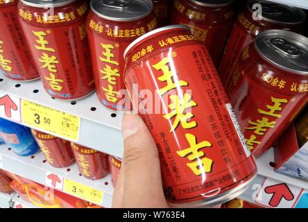 --FILE--A Chinese customer shows a can of Jiaduobao herbal tea, front ...