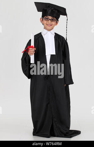 Boy in graduation gown holding a degree Stock Photo - Alamy