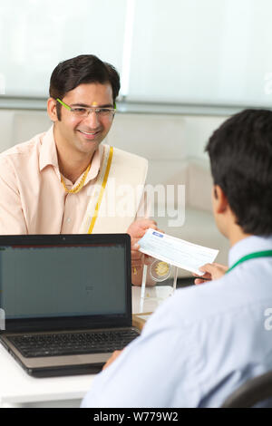 Bank manager giving cheque to his customer as loan Stock Photo - Alamy