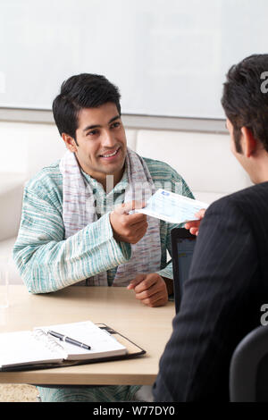 Bank manager giving cheque to his customer as loan Stock Photo - Alamy