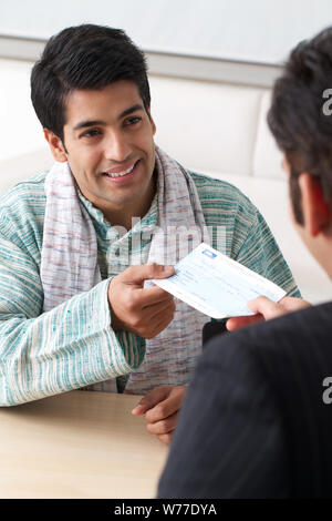 Bank manager giving cheque to his customer as loan Stock Photo - Alamy