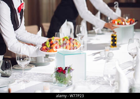 Waiter serving fancy dish to woman sitting at restaurant table Stock ...