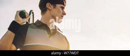 Young male tennis player resting at the tennis court after the game ...
