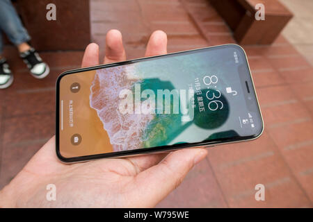 A Chinese customer shows his new iPhone XS Max smartphone at the ...