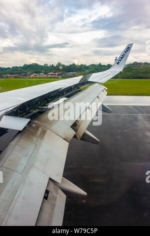 Wing brake flaps open on a Ryanair Boeing 737 - 800 landing in the rain ...