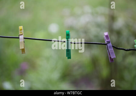 Plastic clothes pegs on a wire Stock Photo - Alamy