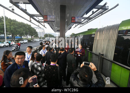 Passengers queue up to take a ride on a railless train, developed by ...