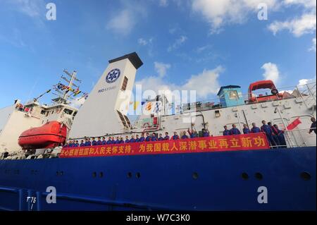 Scientists wave after the mother ship, Tansuo-1, carrying China's ...