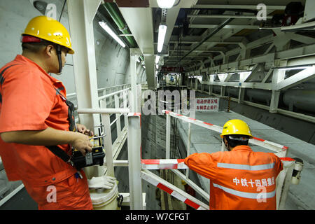 Chinese workers labor at the world's highest power transmission tower lines with a height of ...