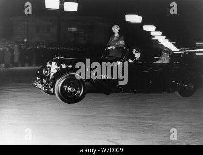 Adolf Hitler in uniform, standing in his official open top Mercedes ...