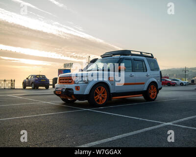 Modified black Land Rover Discovery Series I 4x4 climbing a dusty hill ...