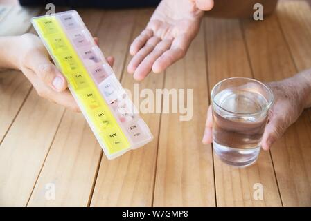 Doctor is assist patient to eat medicine tablet in pillbox correctly ...
