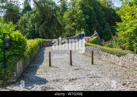 Tourists standing on the Old Brig o'Doon, a 15th-century cobblestone ...