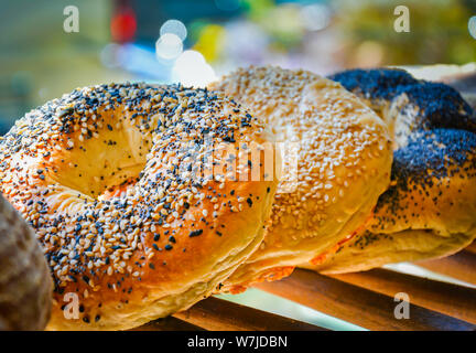 Close up of assorted bagels topped with poppy and sesame seeds on a ...