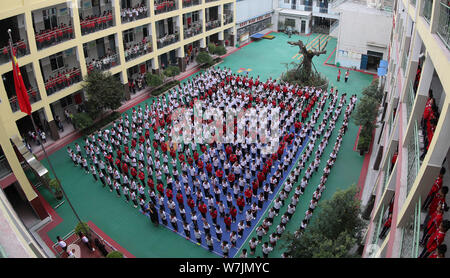 Chinese students salute during a flag-raising ceremony on the first day ...