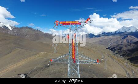 Electricity workers labour on the world's highest power transmission tower with a height of ...