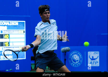 Jared Donaldson of the United States returns a shot to Denis Istomin of ...