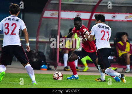 Cameroonian football player Olivier Boumal, center, of Liaoning Whowin ...
