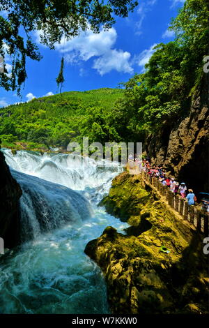 Tourists visit the Huangguoshu Waterfall scenic area in Guiyang City ...